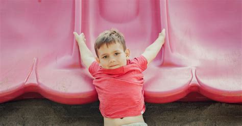 활동적인 행복한 재미있는 미소 백인 소년 아이는 여름 화창한 날에 야외 놀이터 학교 운동장에서 미끄러집니다 재미있게 놀고있는