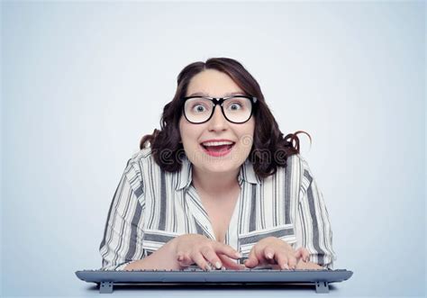 Happy Funny Girl Programmer In Glasses With Keyboard In Front Of