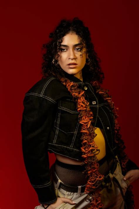 갈색 머리 곱슬머리 긴 머리 모델 빨간색 배경 서 있는 수직 쐈어 스튜디오 촬영 여성 자켓 초상화 패션 사진