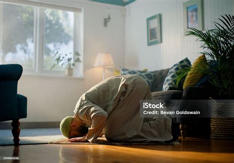 신 예배 및 무슬림 남성은 믿음 감사 또는 영성 이슬람교 종교 및 남성이 알라에 대한 감사 찬양 또는 존경으로 거실에서 두아 기도를합니다 밤 하루 시간대에 대한 스톡 사진