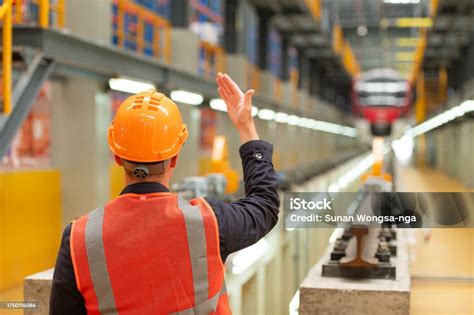 안전 헬멧과 반사 조끼를 입은 전기 열차 산업 엔지니어의 뒷모습 자동차 수리 공장에는 배경 이미지로 전기 자동차가 있습니다 신호원에 대한 스톡 사진 및 기타 이미지 Istock