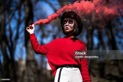 야외 공원에 빨간 화려한 연기 폭탄을 들고 젊은 예쁜 여자 세뇌 축제에서 붉은 연기가 퍼지고 있습니다 거리에 대한 스톡 사진 및 기타 이미지 Istock
