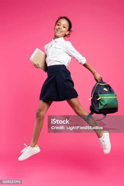 분홍색 배경에 배낭과 책점프 웃고 아프리카 계 미국인 여학생의 전체 길이 보기 아이에 대한 스톡 사진 및 기타 이미지 아이 점프 교복 Istock