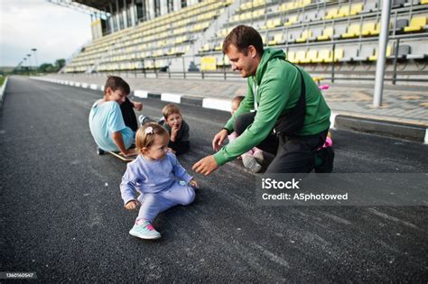 아스팔트 놀이와 재미에 아버지와 네 아이 스포츠 가족은 스쿠터와 스케이트와 야외에서 자유 시간을 보낸다 12 13세에 대한 스톡 사진 및 기타 이미지 Istock