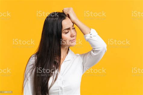 소진 된 젊은 여자의 초상화는 흰색 캐주얼 셔츠에 눈을 감고 스튜디오에서 Brignt 노란색 오렌지 배경에 고립 된 머리에 손을 넣어 사람들 라이프 스타일 개념입니다 복사