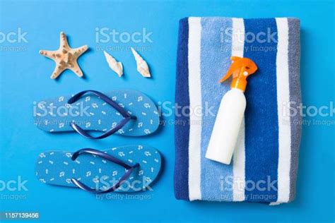 해변 플랫 레이 액세서리의 상단보기 조개 불가사리 수건 및 플립 플롭과 복사 공간이있는 컬러 배경의 선스크린 병 0명에 대한