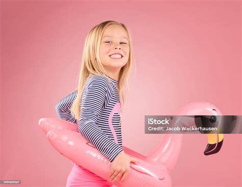 행복하고 초상화와 수영장은 수영 여름 방학 또는 귀여움을 위해 스튜디오에서 소녀와 함께 떠 있습니다 젊음 재미 있고 풍선 아이와 플라밍고 반지는 분홍색 배경에 휴식 미소