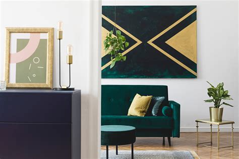 석류 선반 골드 테이블 램프 포스터 프레임 소파 식물 및 우아한 액세서리와 거실의 현대적이고 고급스러운 인테리어 벽에 그림을 디자인합니다 세련된 홈 장식 템플릿 0명에 대한