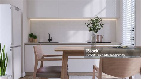 카운터 찬장 냉장고 정사각형 타일 스플래시백 쪽모이 세공 마루 바닥에 창문 블라인드가 있는 흰색 주방 룸에 꽃다발 유리 꽃병이 있는 현대적이고 미니멀한 갈색 나무 식탁