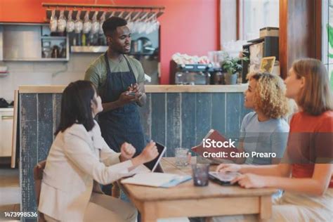 세 명의 다민족 프리랜서 여성의 테이블에서 주문을 받는 아프리카계 미국인 바 주인 직원에 대한 스톡 사진 및 기타 이미지 직원 레스토랑 소기업 Istock