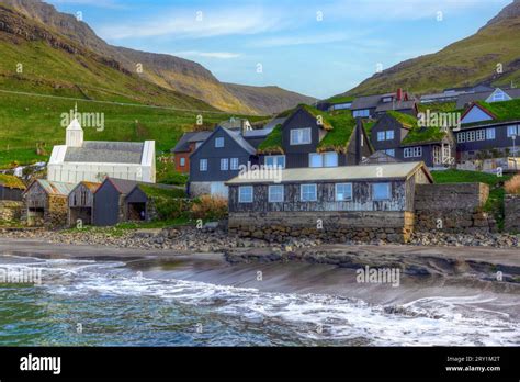Turfed Houses And Sea Stack Tindholmur In Bour Faroe Islands Stock