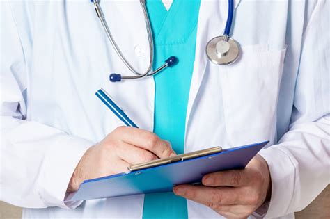 클로즈업 흰색 의료 코트에서 자른 남자 의사는 환자의 카드에 뭔가를 씁니다 빛 사진입니다 개념에 대한 스톡 사진 및 기타 이미지 Istock