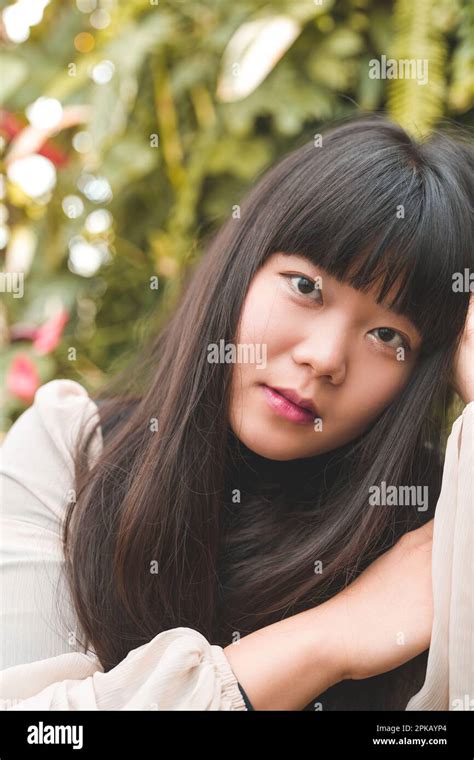 Close Up Of Young Asian Woman In A Garden Warm Brown Tones Bangs