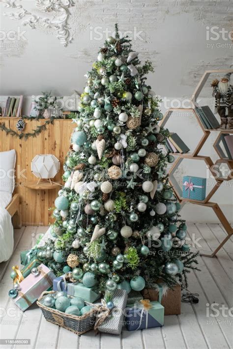 그 아래에 크리스마스 선물과 아름답게 장식 된 집에서 크리스마스 트리 나무는 침대 옆에 서 있다 0명에 대한 스톡 사진 및 기타