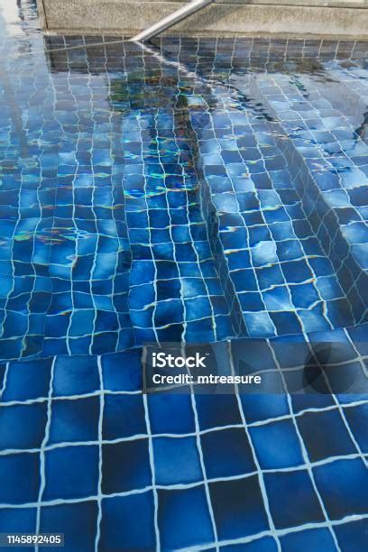 깊은 물과 수영을 학습 하는 어린이를 위한 수영의 크롬 난 간 건강과 안전으로 이어지는 고급 수영장 단계 이미지 작은 파란색 모자이크 풀 타일과 물결 모양의 물이 왜곡 된