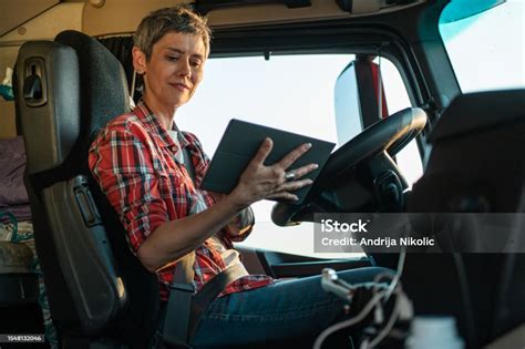 Female Trunk Driver Sitting Inside Of A Cabin And Using Tablet Stock