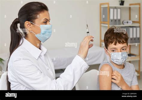 Doctor Or Nurse With A Syringe Is Going To Give A Vaccine To A Little