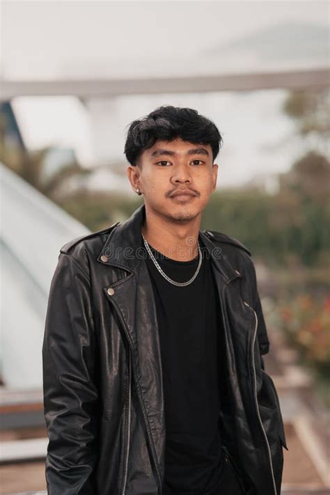 A Grown Man In A Black Leather Suit And Chain Necklace Posing Very