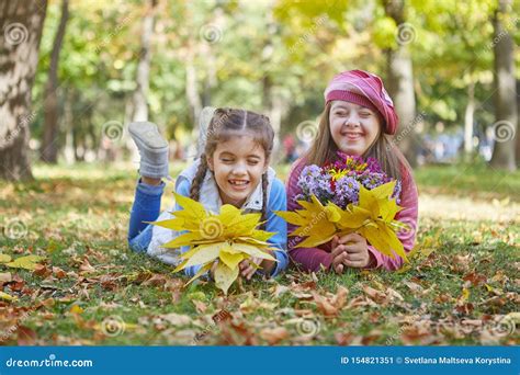 M Dchen Mit Down Syndrom Und Kleines M Dchen Im Herbst Parken Stockbild Bild Von Lustig