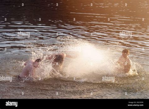 Adult Men Splashing In The Water People Play In Water Silhouettes Of Men Playing In The Pond