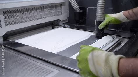 A Male Worker Cleans The Surface Of An Industrial 3d Printer From White