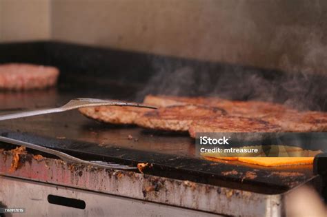 정원 파티 숯불 바베큐 큰 햄버거 쇠고기 햄버거 튀김과 요리 그릴에 완벽하게 굽는 불타는 연기 치즈 버거 치즈 조각으로 돌리는 햄버거와 연기가 자욱한 바베큐 요리 길거리