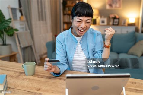 집에서 디지털 태블릿과 신용 카드를 사용하는 쾌활한 일본 여성 가정 생활에 대한 스톡 사진 및 기타 이미지 가정 생활 구매