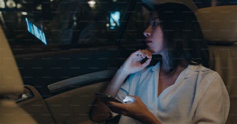 패션 사무복을 입은 성공적인 젊은 아시아 사업가는 밤에 도시 현대 도시의 뒷좌석에 앉아 스마트폰을 사용하여 늦게까지 일하고 있다 사람들 직업 소진 증후군 개념 사진