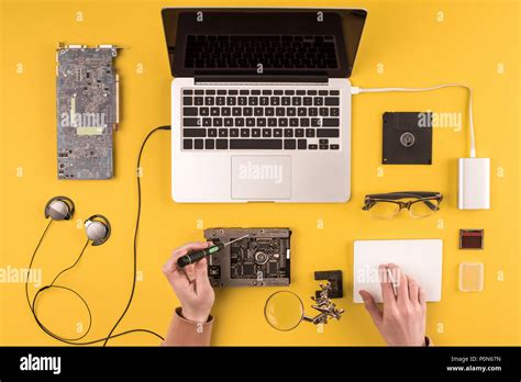 Cropped Shot Of Person Fixing Laptop On Yellow Stock Photo Alamy