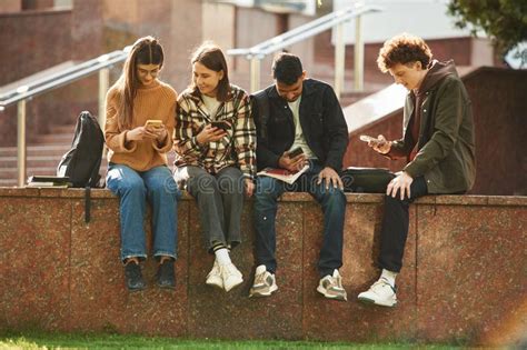 With Education Material In Hands Notepads Four Young Students In