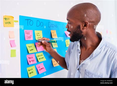 black developer writes ticket on scrum board sprint planning coding