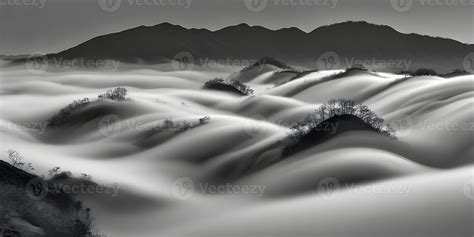 A Serene Monochrome Landscape Features Fog Rolling Over Undulating