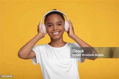 행복한 십대 예쁜 Afro 미국 소녀 에 흰색 티셔츠 에 헤드폰 듣기 음악 노란색 배경에 고립 아이에 대한 스톡 사진 및 기타 이미지 Istock