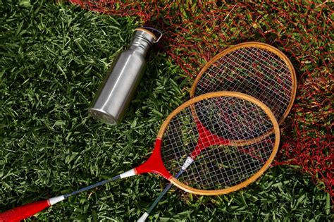 Free Photo Badminton Rackets And Flask On Grass