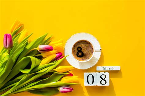 배너뜨거운 모닝 커피 한 잔과 밝은 노란색 배경에 노란색 라일락 튤립 꽃다발 위에서 본 모습 클로즈업 텍스트 공간을 복사합니다 휴일과 좋은 아침 소원의 개념 0명에 대한