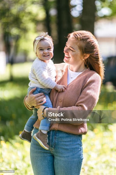 한 젊은 어머니가 한 살 짜리 아기와 함께 걷고 그를 품에 안고 안고 있다 그의 조화로운 발전을위한 아이와의 의사 소통 2명에 대한 스톡 사진 및 기타 이미지 Istock