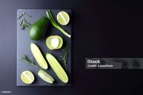 녹색 과일 그리고 야채 어두운 슬레이트 보드에 자연 그린 제품의 개념입니다 아보카도 키 위 라임 및 어두운 배경에 애플 로즈마리 딜과 돌 보드에 향신료 건강한 생활방식에