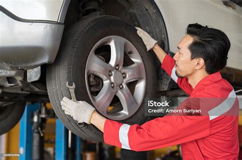 남자 수리 유지 보수 및 차량 서비스를 위해 차고에서 정비사로 엔진을 작업하는 자동차 정비사 정비사가 휠을 검사하고 교체합니다 중소기업 신생 기업 및 차고 개념 30 34