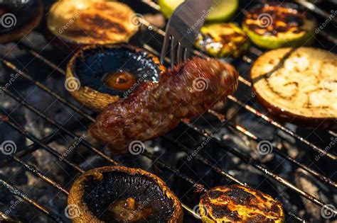Grilling Meat Rolls Called Mici Or Mititei With Vegetables On Char Barbecue Charcoal Grill With