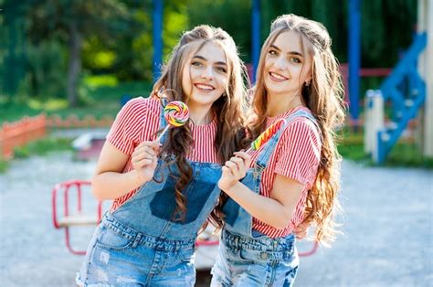 Premium Photo Two Beautiful Twin Girls Hugging And Laughing In Denim