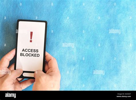 Hand Holding A Mobile Phone With Restricted Site And Website Blocked