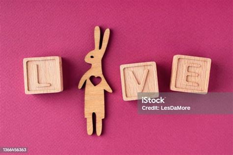 사랑이라는 단어는 밝은 분홍색 배경 평면 상단 보기에 나무 큐브로 구성되어 있습니다 사랑의 메시지 발렌타인 데이 어머니의 날 여성의 날 3 월 8 일 인사말 카드의 개념 0