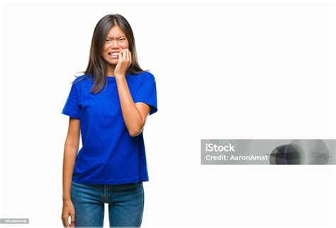 젊은 아시아 여자 찾고 스트레스와 긴장 하는 고립 된 배경 위에 손톱을 물어 뜯고 입에 손 불안 문제입니다 감정에 대한 스톡 사진 및 기타 이미지 Istock