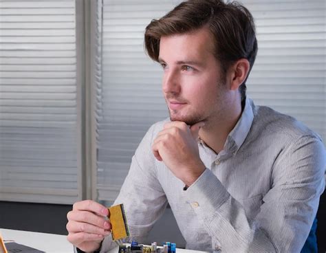 Premium Photo Thoughtful Engineer With Semiconductor At Office