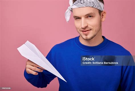 진한 파란색 스웨터를 입은 펑키 한 세련된 남자가 종이 비행기와 함께 분홍색 배경에 서 있습니다 경영자에 대한 스톡 사진 및 기타 이미지 Istock