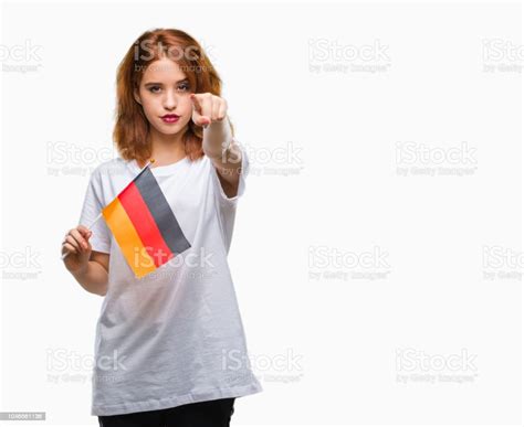 당신에 게 카메라를 손가락으로 가리키는 격리 된 배경 위에 독일의 젊은 아름 다운 여자 들고 국기 손 기호 정면에서 긍정적이 고
