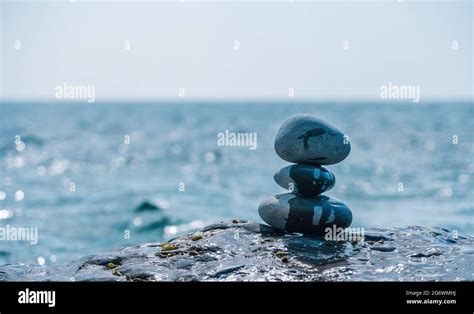 Balanced Pebble Pyramid On The Beach On A Sunny Day Abstract Sea Bokeh
