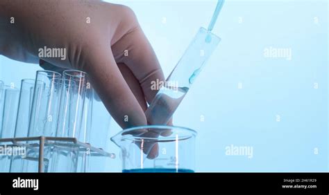 Hand Of Scientist Holding Flask With Lab Glassware And Test Tubes In Chemical Laboratory