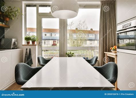 Una Sala Con Grandes Ventanales Y Una Mesa Blanca Foto De Archivo