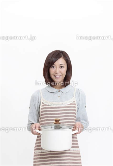 鍋を持つ中年女性 イメージマート